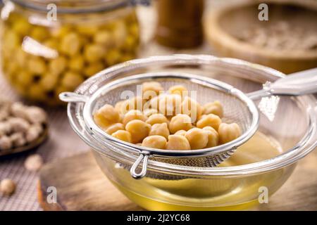 chickpeas being sieved to extract aquafaba, cooking liquid used as an ...