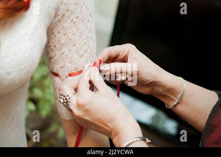 bridesmaid tying a ribbon on elegant, possible wedding white bridesmaid ...