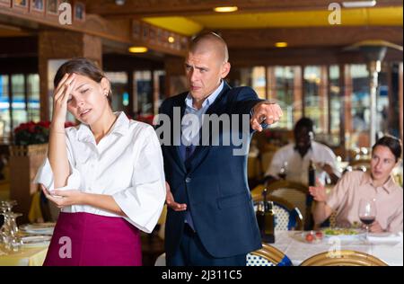 Angry man client of restaurant yelling at young waitress Stock Photo ...