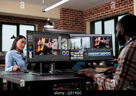 Creative company professional movie footage editor sitting at multi ...