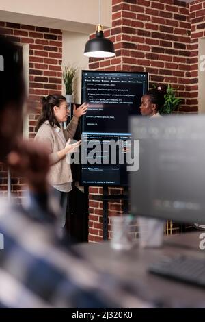 System engineers using binary code to script security system, working in it development agency ...