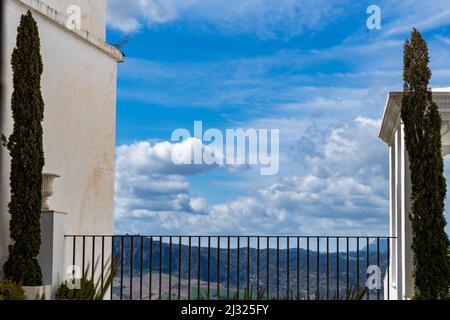 a balcony with trees in the background and blue sky above, as seen from ...
