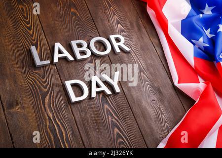 words labor day laid with silver metal letters on wooden surface with ...
