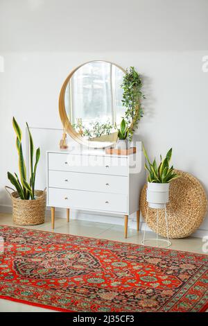 Mirror, houseplants and pouf near light curtain in room Stock Photo - Alamy