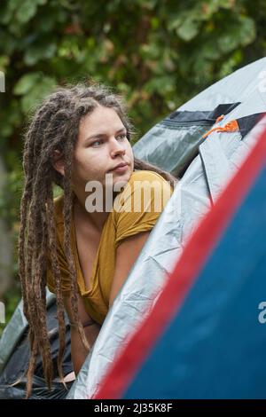 Woman getting out the tent Stock Photo - Alamy