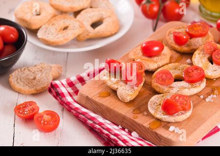 Friselle with cherry tomatoes and olive oil Stock Photo - Alamy