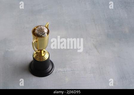 Brain inside gold cup trophy with copy space. Winning mentality and ...