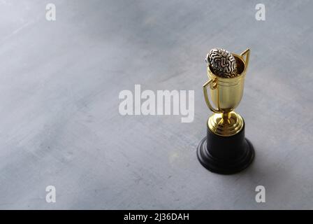 Brain inside gold cup trophy with copy space. Winning mentality and ...