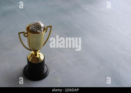 Brain inside gold cup trophy with copy space. Winning mentality and ...