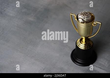 Brain inside gold cup trophy with copy space. Winning mentality and ...