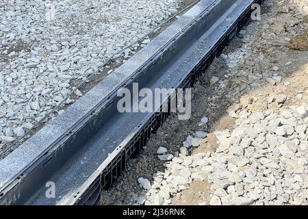 Laying drainage pipe for rain water on car parking lot is covered ...