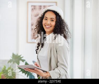 Young female designer with big tablet computer on pink background with ...