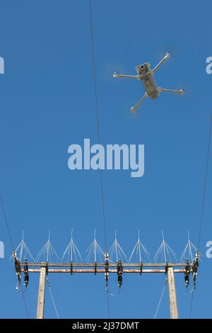 Aerial view of electricity pylon and high voltage line against city ...