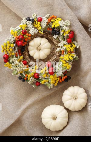 Autumn wreath with rose hip, tansy and spiraea on white wooden ...