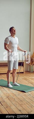 Strong man using resistance bands at home Stock Photo - Alamy