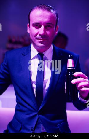 Guy drinking beer in a nightclub Stock Photo - Alamy