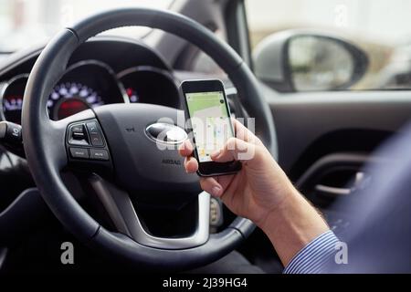 Let your GPS guide you. Closeup shot of a driver in a car using a ...