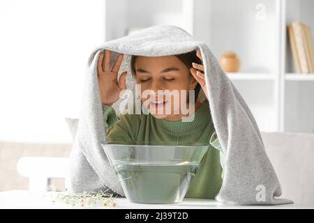 Young woman doing steam inhalation at home to soothe and open nasal ...