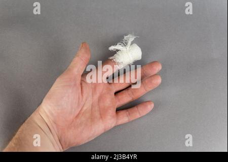 The hand of a mature man with a bandaged index finger. The man holds ...