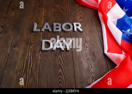 words labor day laid with silver metal letters on wooden surface with ...