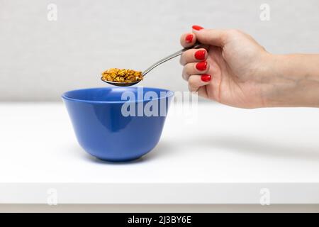 Female hand with a manicure holds oatmeal cookies with cereals over ...