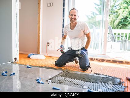 nice handyman install tile on the floor Stock Photo - Alamy