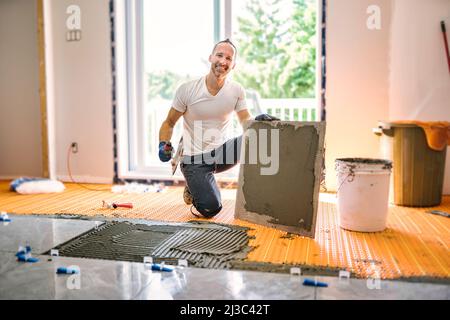 nice handyman install tile on the floor Stock Photo - Alamy