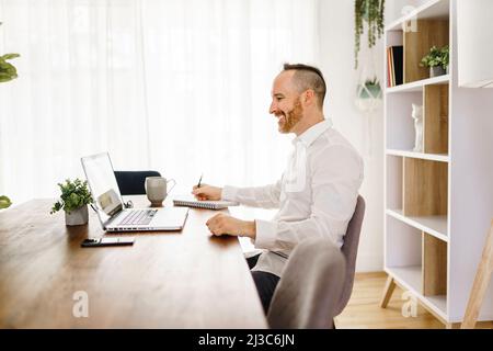 Nice mature man working on laptop at home Stock Photo - Alamy