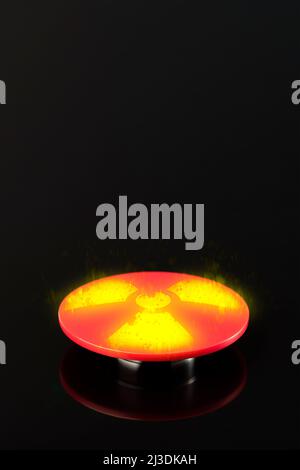 Big red button with the symbol of nuclear weapons on a black background ...