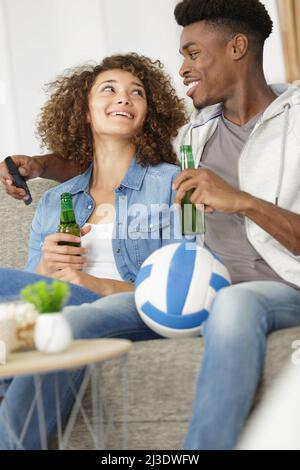 Couple Watches TV together while Sitting on a Couch in the Living Room ...
