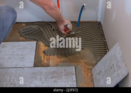Installation of ceramic tiles. The tiler's hands are fixing the tile ...