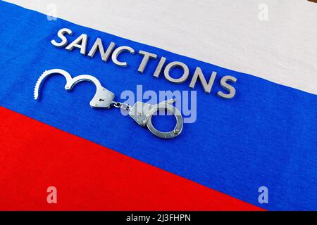 the word sanctions laid with silver metal letters on russian tricolor ...