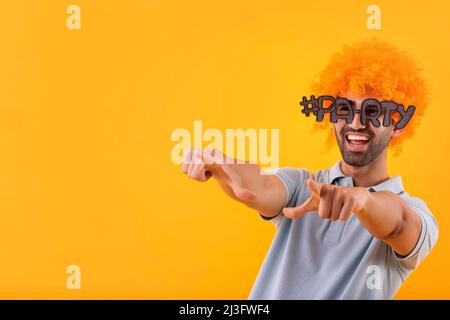 Crazy funny young man wearing party glasses with orange wig Stock Photo ...