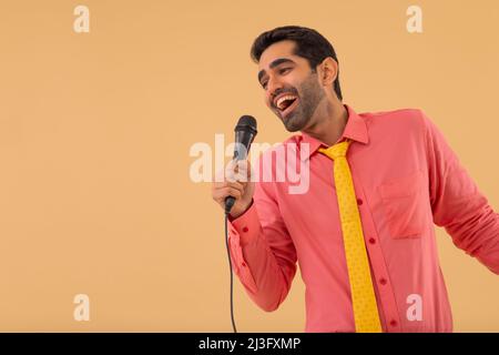 Happy corporate man singing on microphone Stock Photo - Alamy