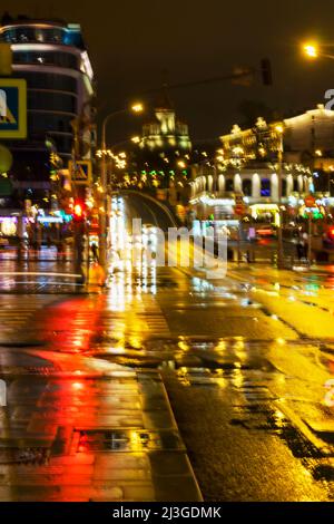 Defocused street lamps and reflection on a water, night city life ...