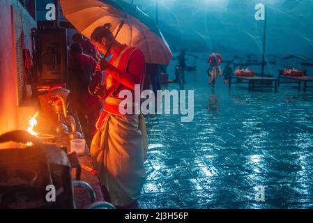 Nepalese Hindu priests perform evening Aarti ceremony during heavy rain ...