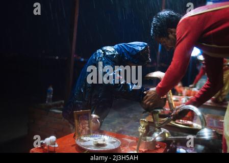 Nepalese Hindu priests perform evening Aarti ceremony during heavy rain ...