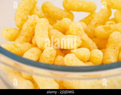 Yellow Corn Puffs in a Glass Bowl. Crunchy Flavored Puffed Snacks ...