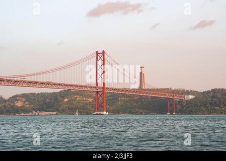 The 25 de Abril Bridge supension bridge of Lisbon at Sunset. Beautiful ...
