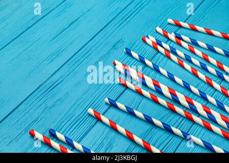 Stylish straws for drinks on blue wooden background Stock Photo - Alamy