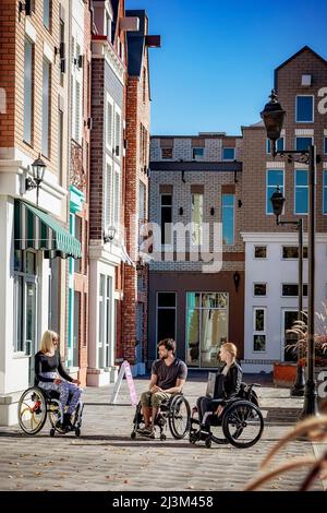 Three young paraplegic friends spending time together moving across a ...
