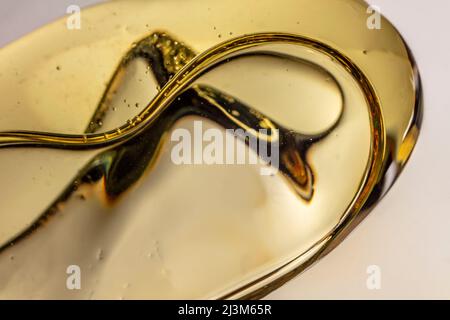 Macro photograph of burst Omega 3 capsule against a plain background ...