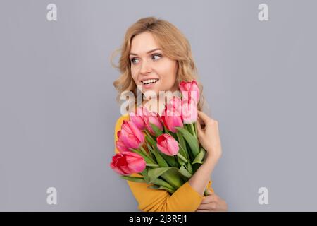 positive woman with tulips. lady hold flowers for spring holiday. girl ...