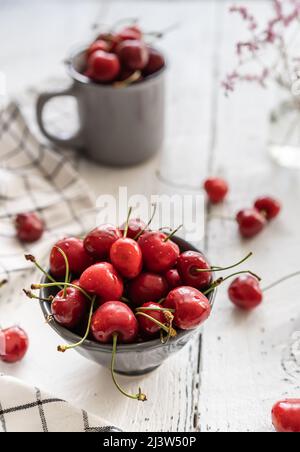 Cup of ripe cherries on a wooden background Stock Photo - Alamy