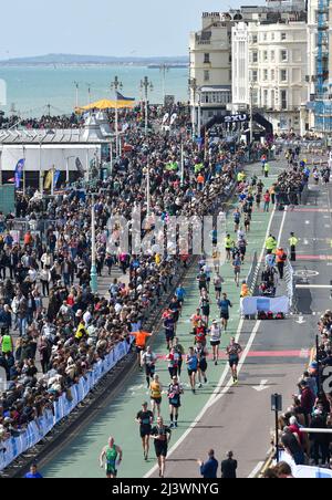 Brighton UK 10th April 2022 - This runner gets a hand from fellow ...