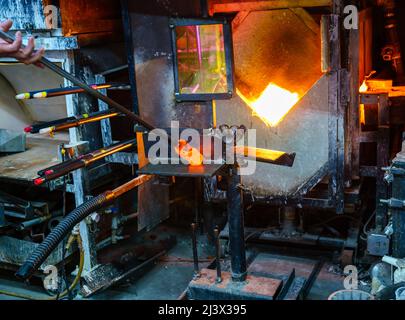 Shaping the hot glass gather during glassblowing process Stock Photo ...