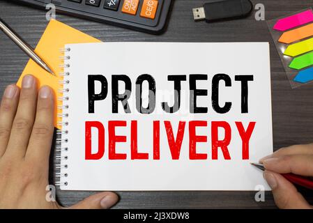 businesman hold notepad with text PROJECT DELIVERY. White background ...