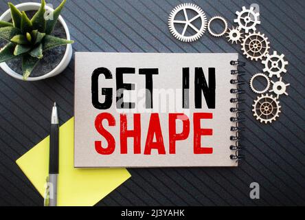 Get in shape - handwriting on notepad with dumbbell, green apple and ...