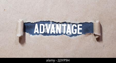 Advantage word on page and paper dollar signs around on wooden table ...