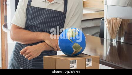 Globe against mid section of person using laptop at office Stock Photo ...